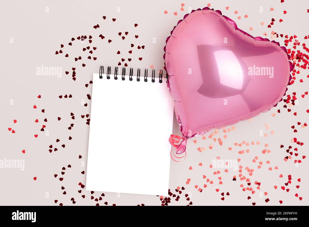 Blank notepad mockup, confetti and pink inflatable foil balloon on a ...
