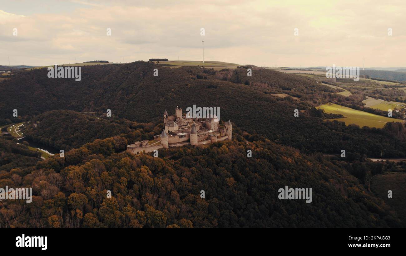 The aerial view of Bourscheid Castle on the hill with lush vegetation ...