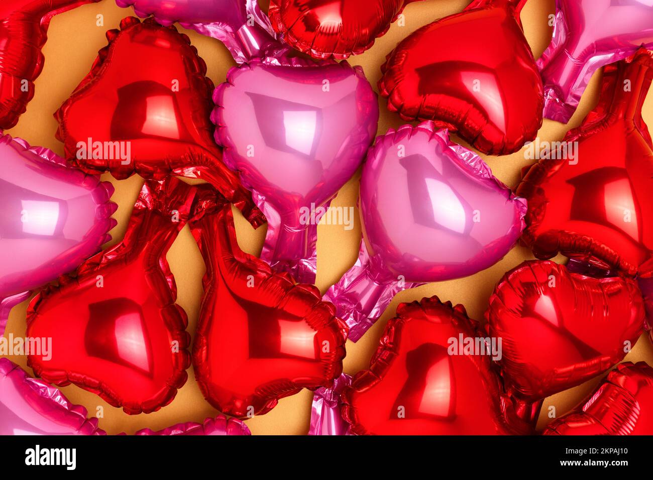 Texture made of red an pink inflatable foil balloons in a heart shape ...