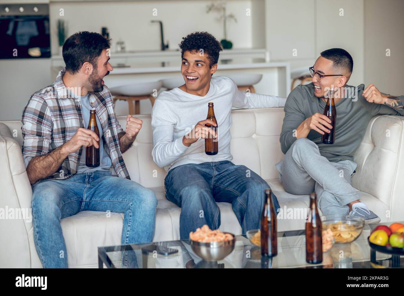 Merry young man communicating with his buddies at home Stock Photo - Alamy