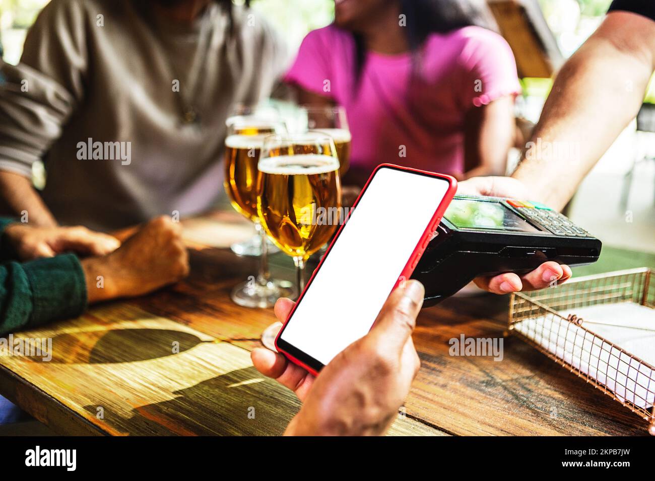 Customer using mobile phone to pay the bill in a bar Stock Photo - Alamy