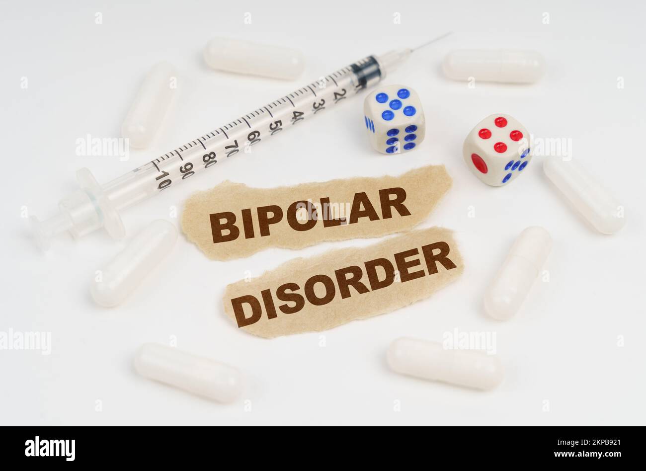 Medical concept. On a white surface lies a syringe, pills, dice and ...