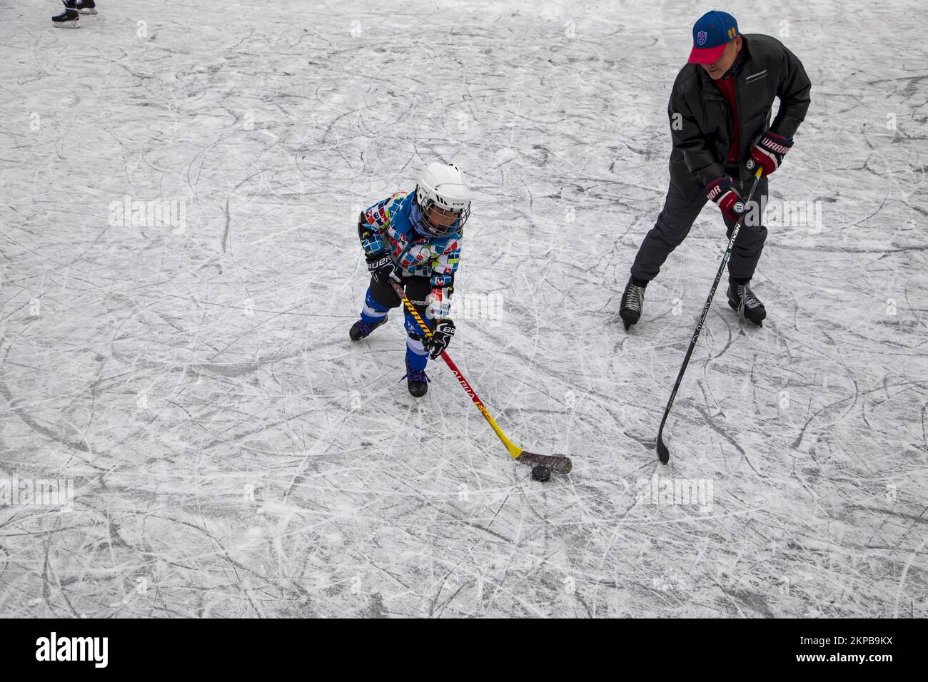 A boy is learning to play ice hockey on the Beishanxi Lake in Jilin ...