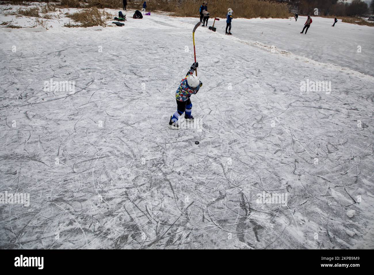 A boy is learning to play ice hockey on the Beishanxi Lake in Jilin ...