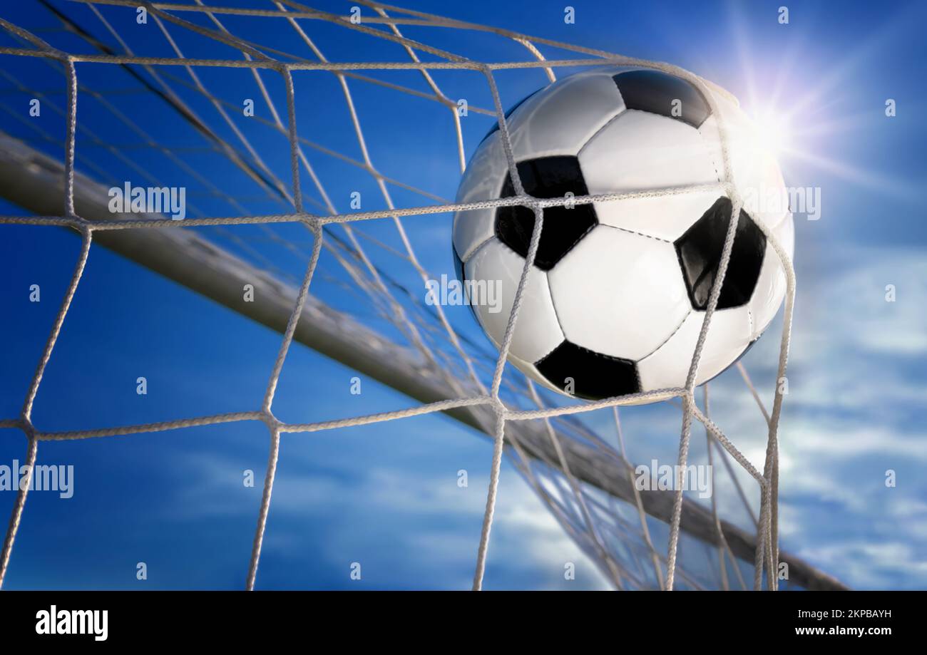 Football or soccer goal, a ball with classic design flying into the net ...