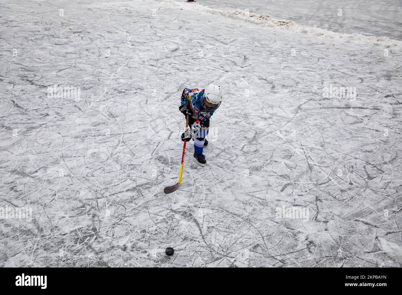 A boy is learning to play ice hockey on the Beishanxi Lake in Jilin ...