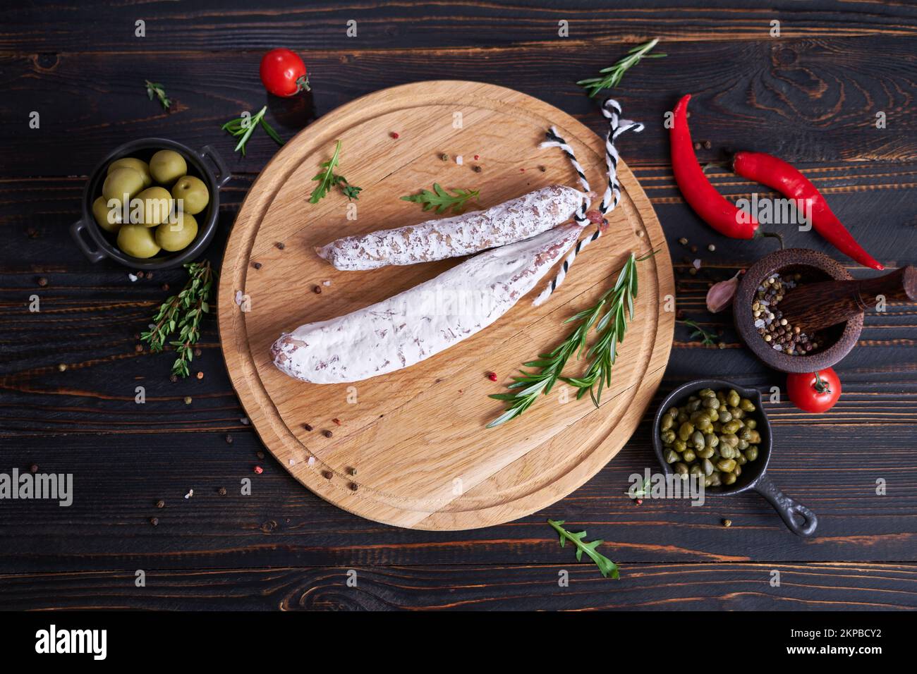 Spanish fuet salami sausageon wooden cutting board at domestic kitchen ...