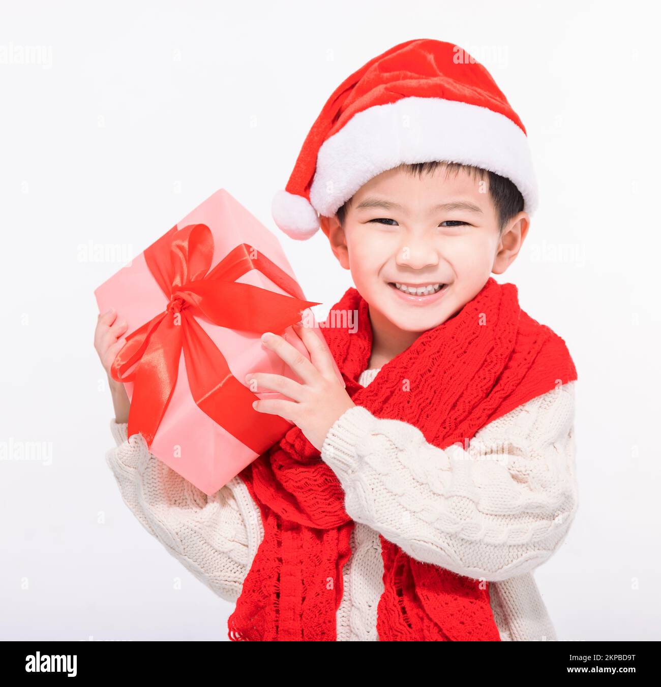 Happy little boy dressed in christmas Santa hat and holding gift box ...