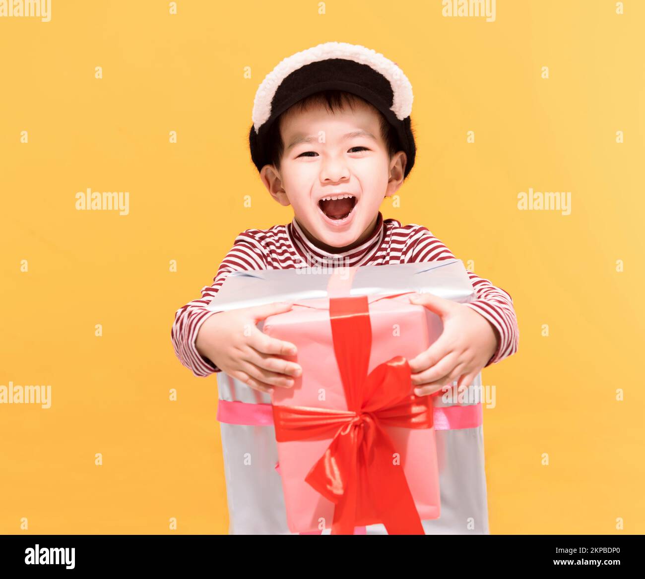 Happy little boy dressed in winter clothes and holding gift box Stock ...