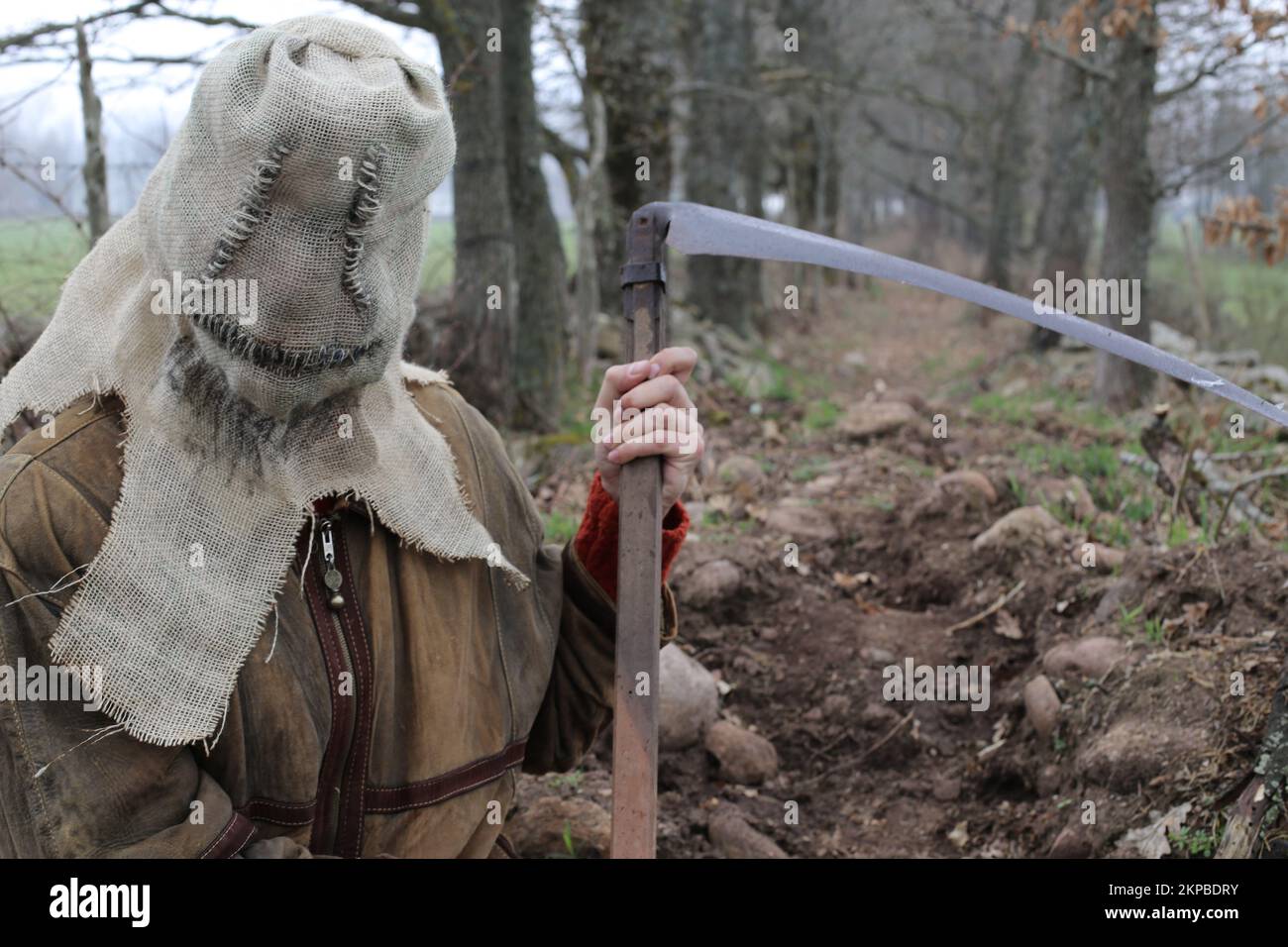 Spooky masked man in cemetery entrance Stock Photo - Alamy