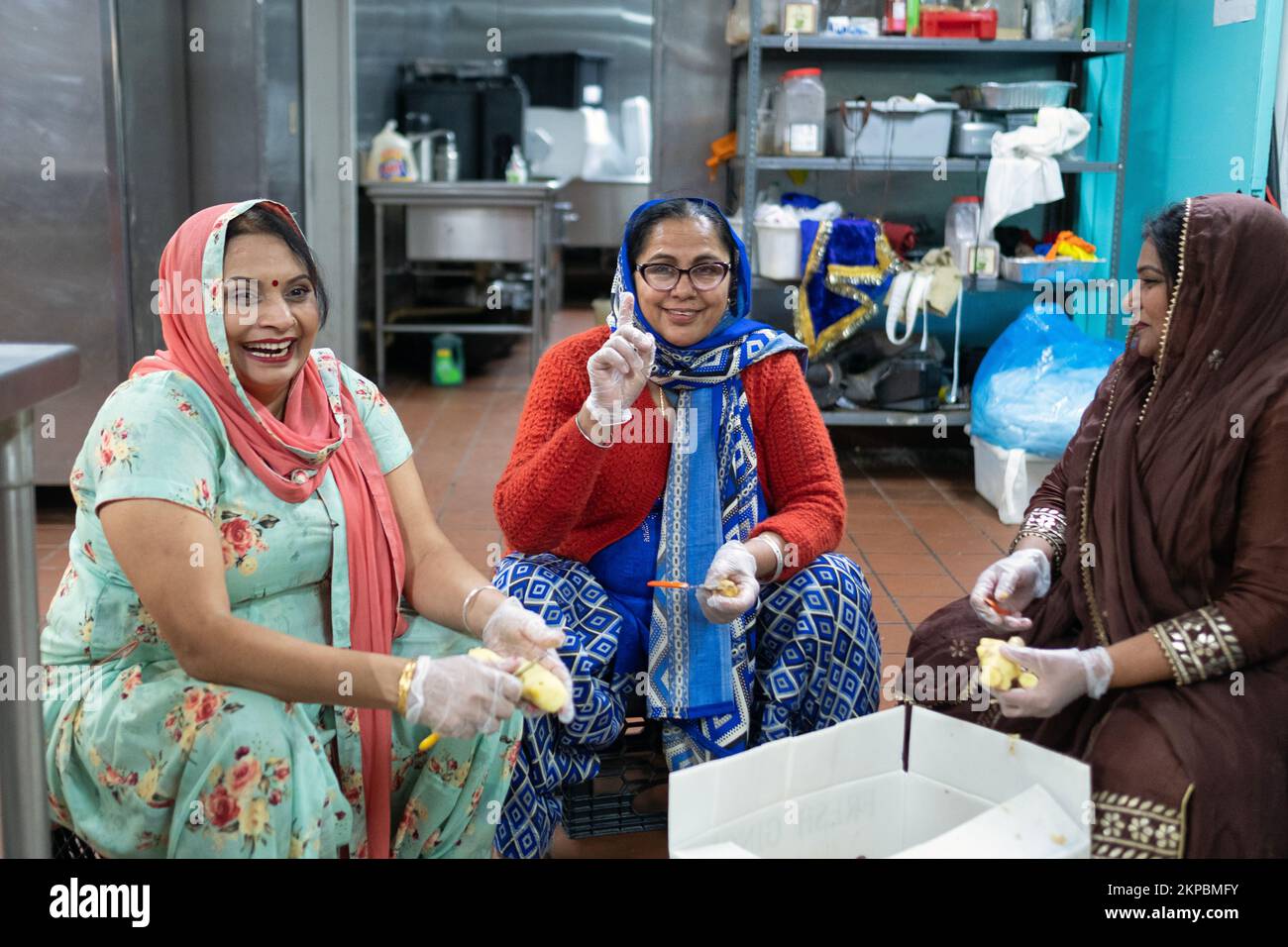 Posed portrait of 3 Sikh women who volunteer preparing food for the ...