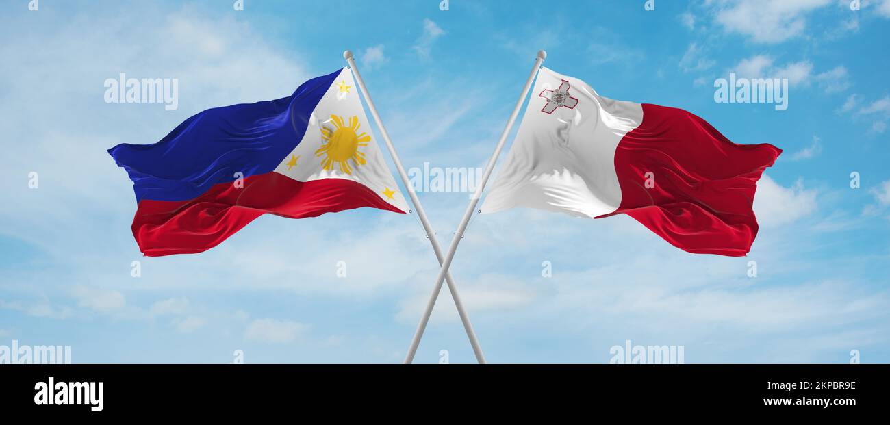 two crossed flags Malta and Philippines waving in wind at cloudy sky ...