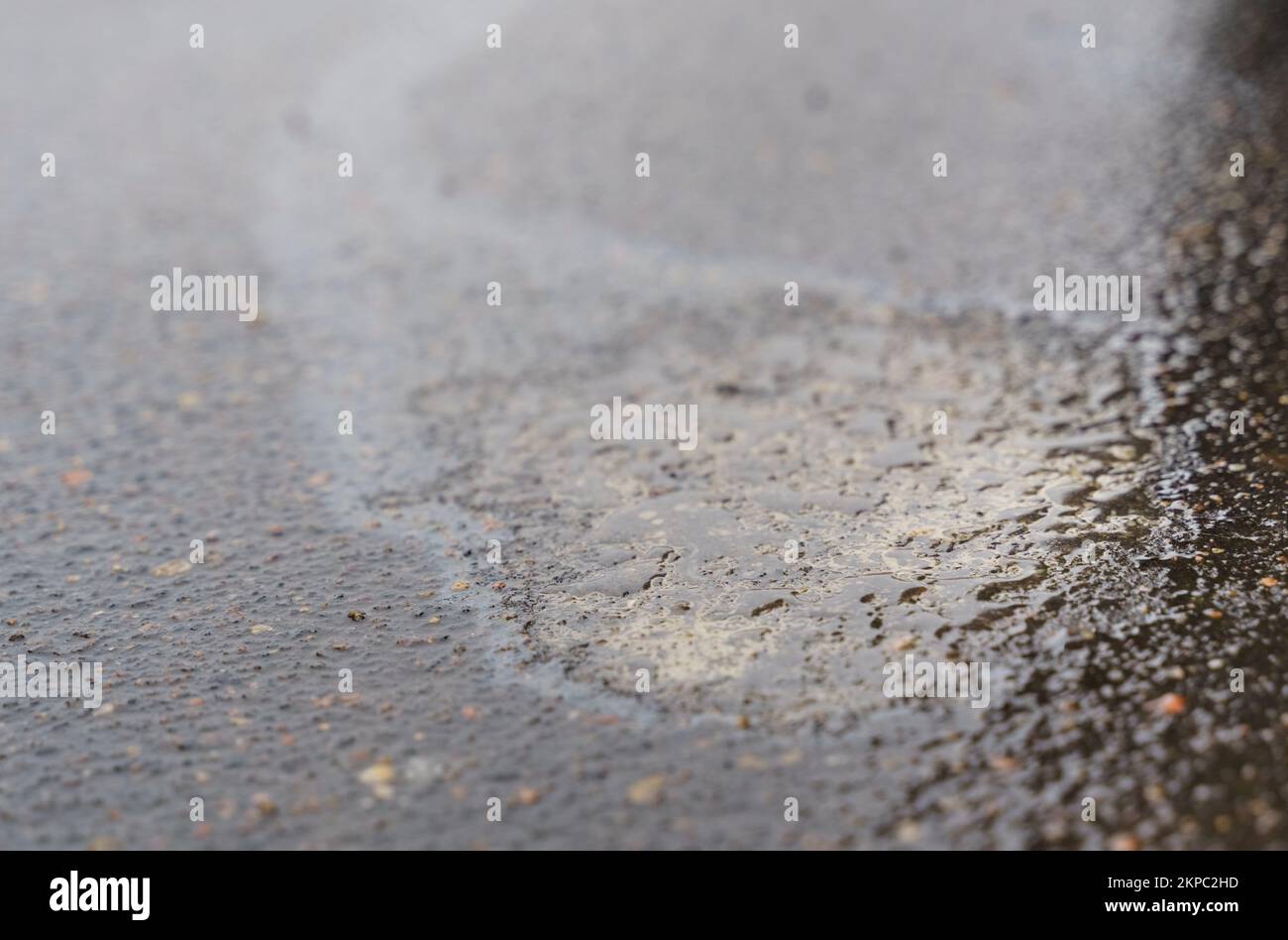 Environmental pollution concept. On the asphalt there is a rainbow ...