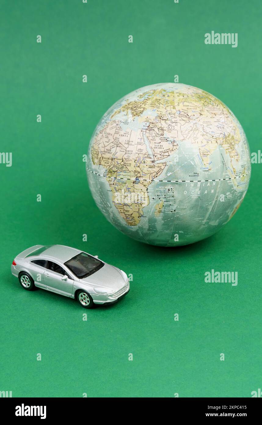 Toy car near the globe. Isolated on a green background. Travel and ...