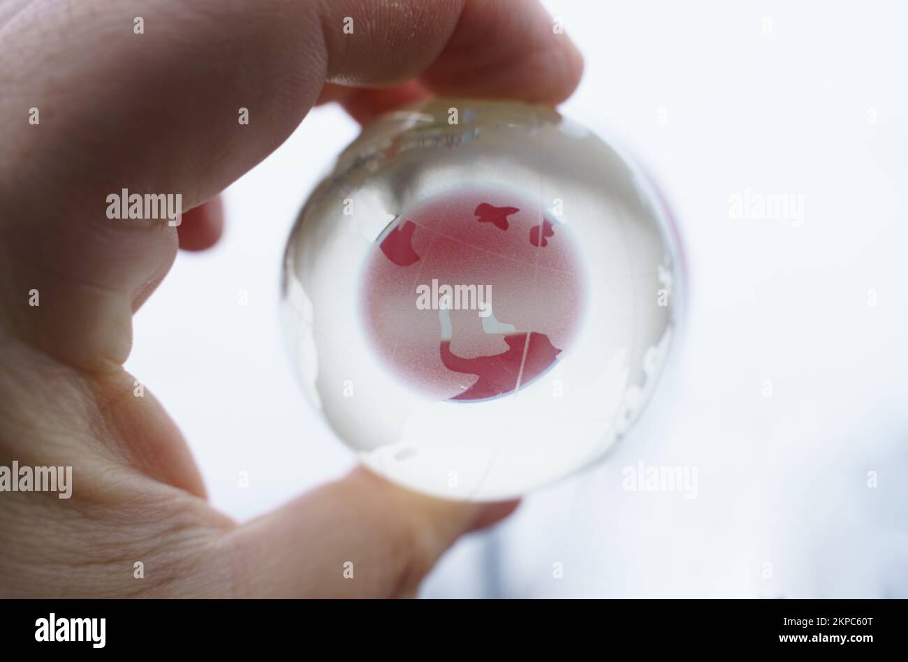 Global ban concept. In the hand is a glass globe, through which a ...