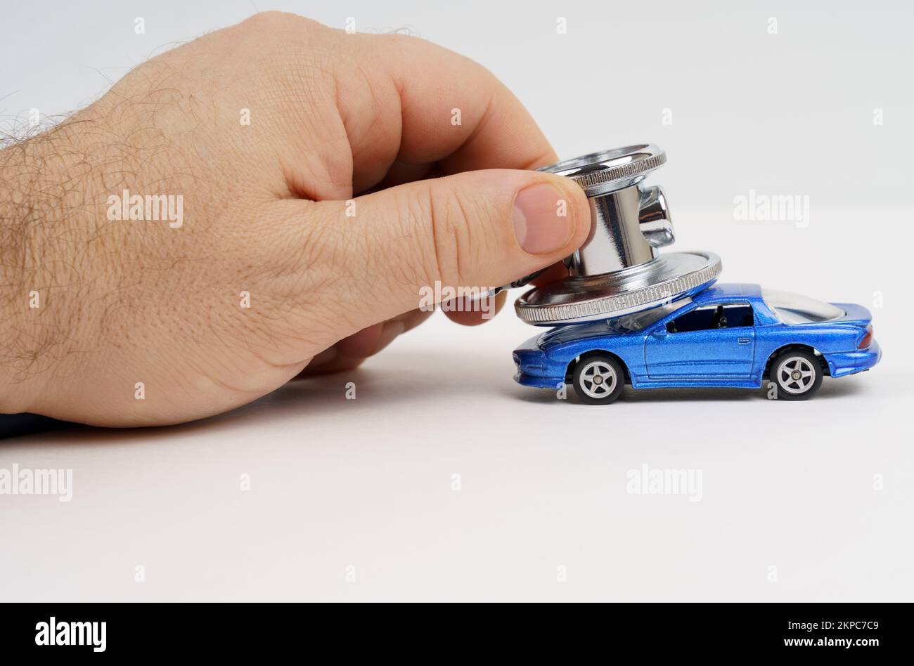 Automotive diagnostics. A stethoscope lies on the roof of a toy car ...