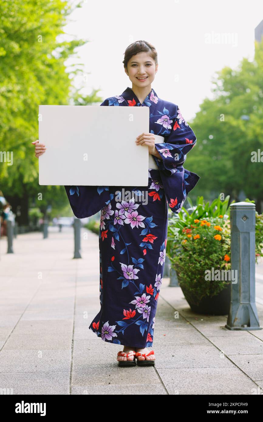 Japanese woman in a yukata holding a whiteboard Stock Photo - Alamy