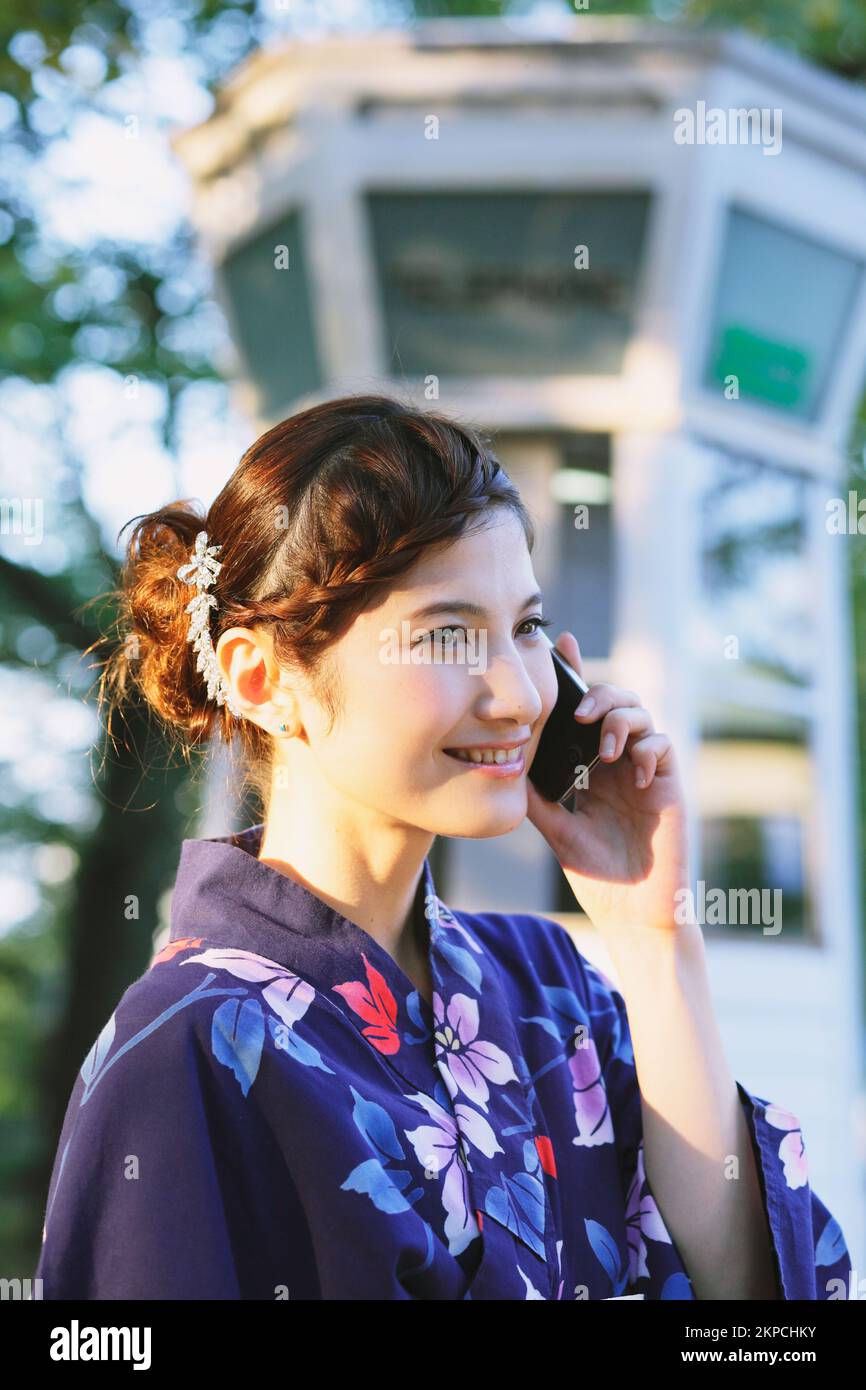Japanese woman in a yukata making a phone call Stock Photo - Alamy