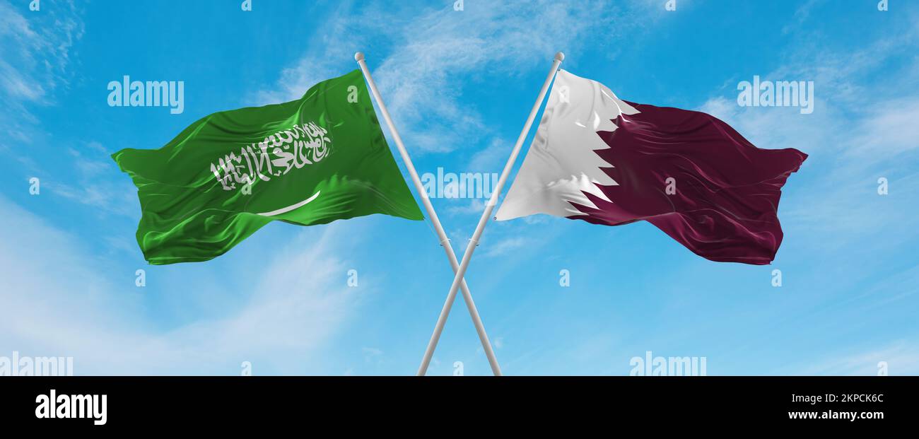 two crossed flags Qatar and Saudi Arabia waving in wind at cloudy sky ...