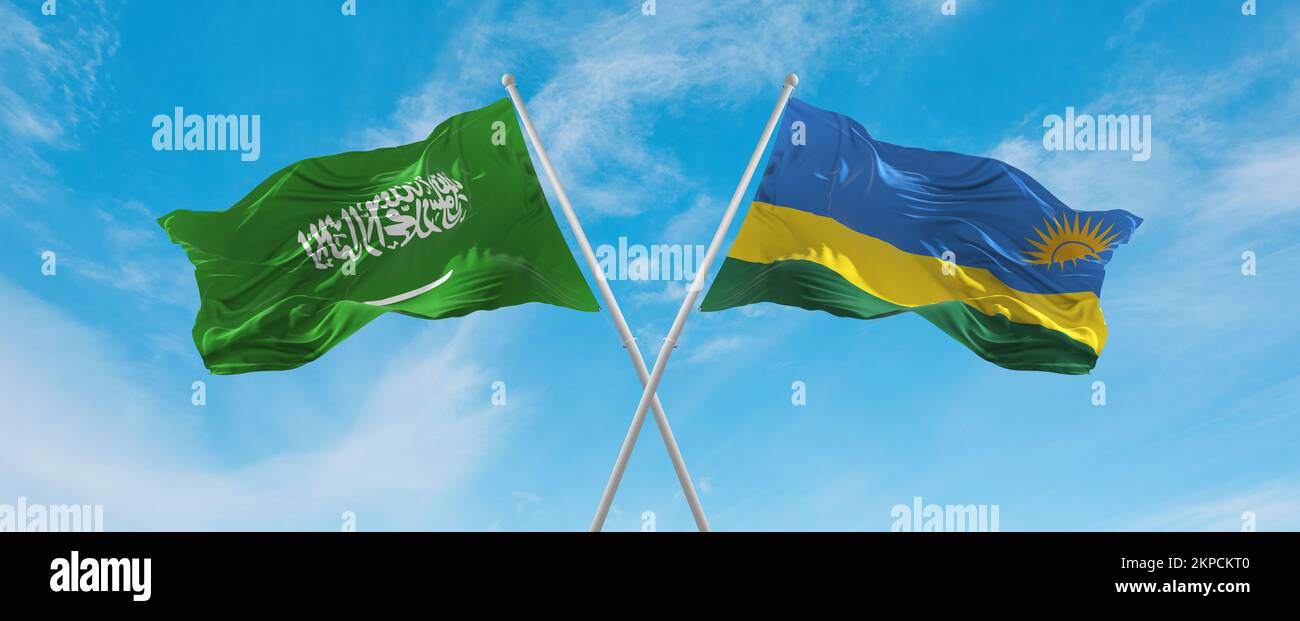 two crossed flags Rwanda and Saudi Arabia waving in wind at cloudy sky ...