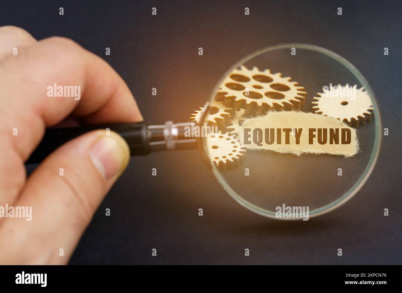 Business and finance concept. In his hand is a magnifying glass through ...