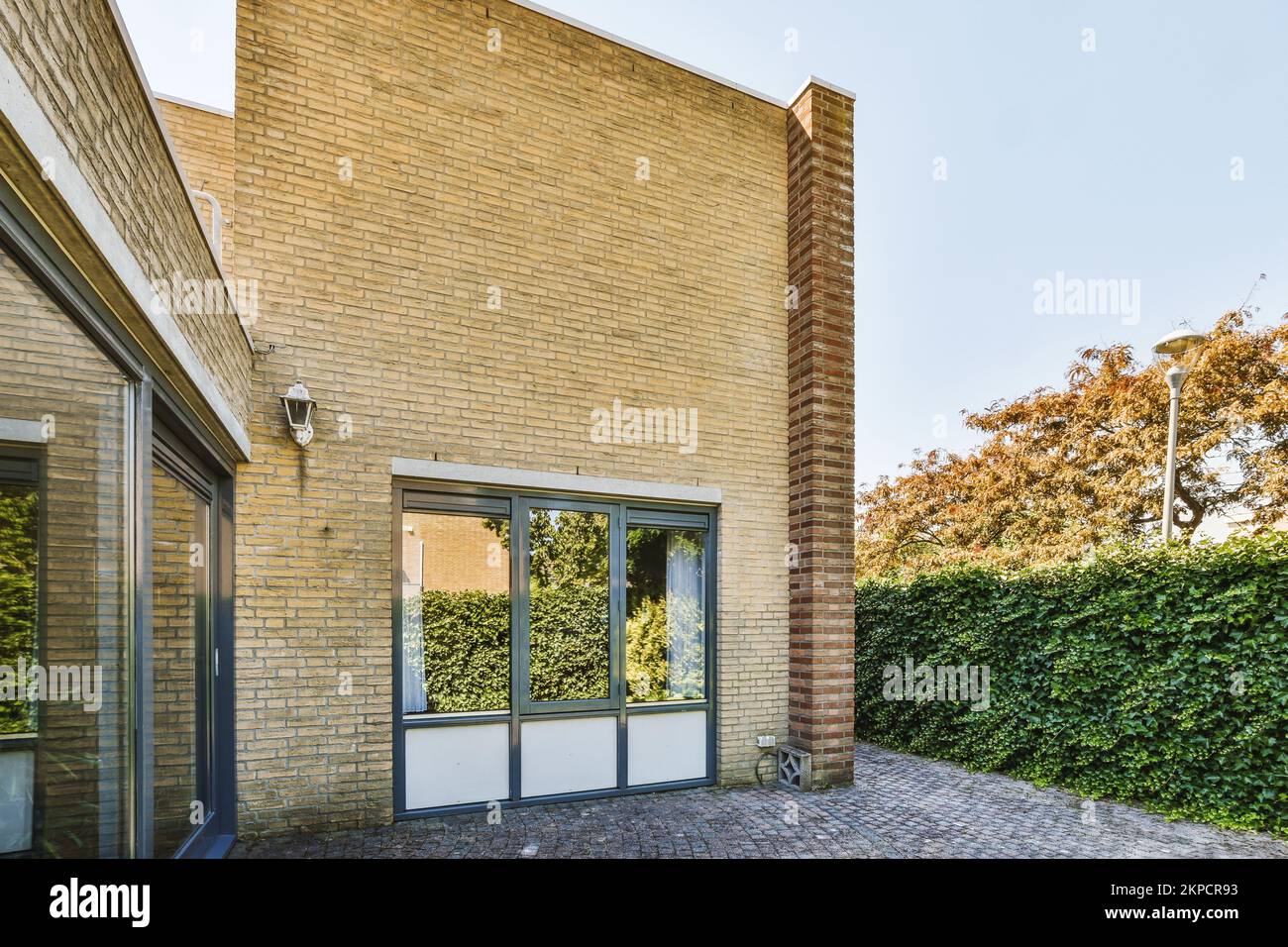 The front view of a brick building with signs,pavement and wooden doors ...