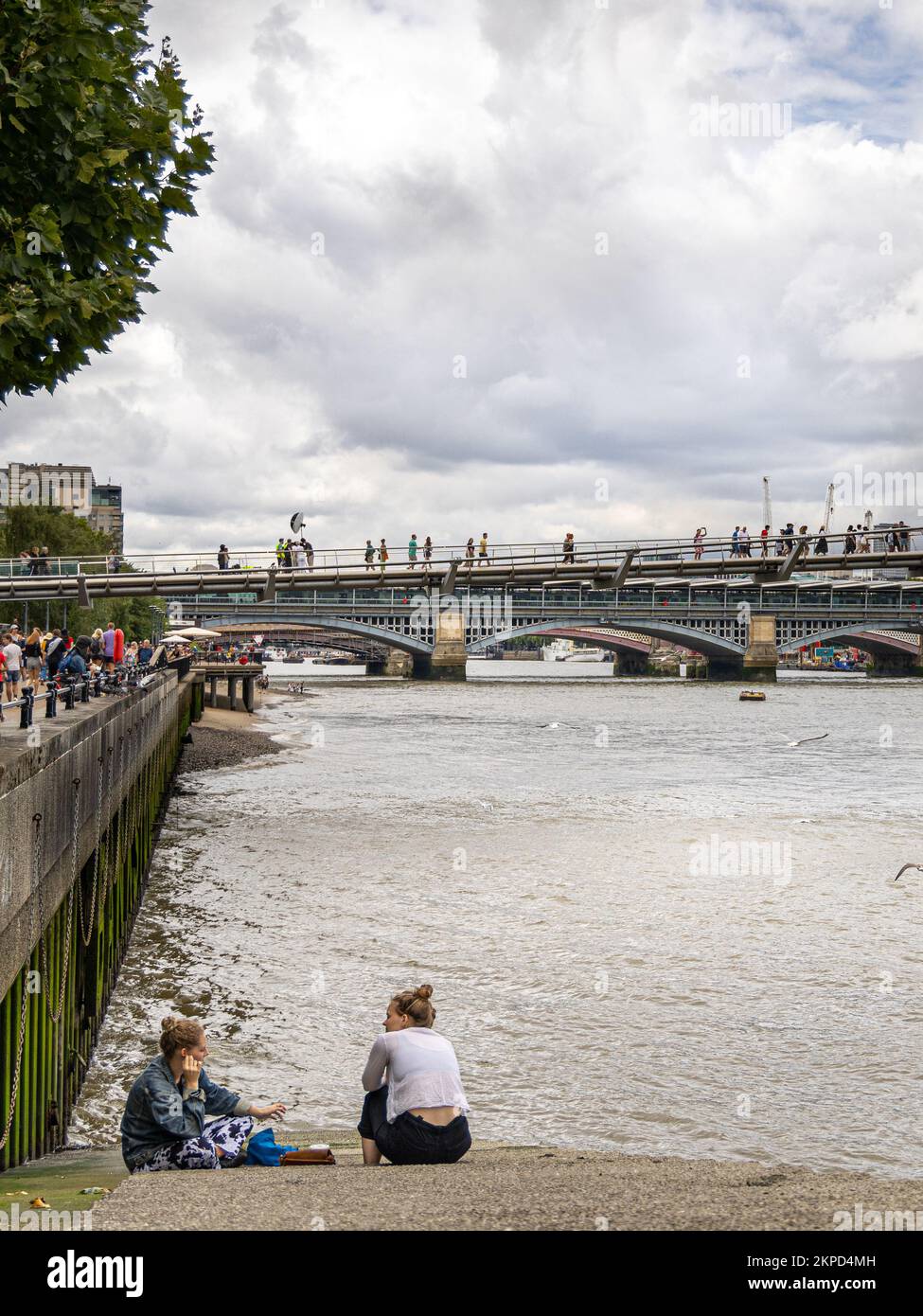 Women sitting on steps, River Thames, South Bank London England Stock ...