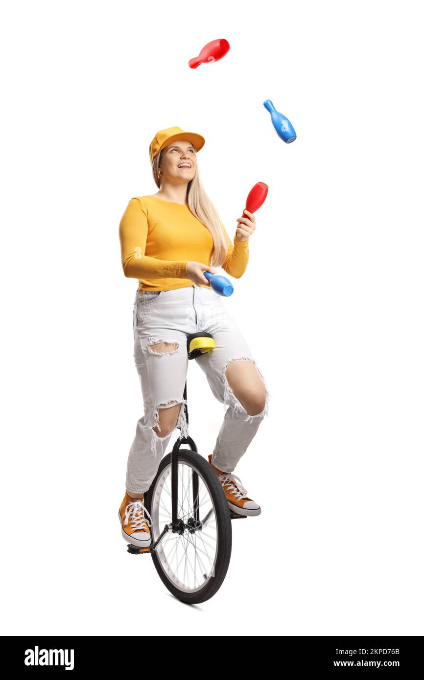 Young female riding a mono cycle and juggling isolated on white ...