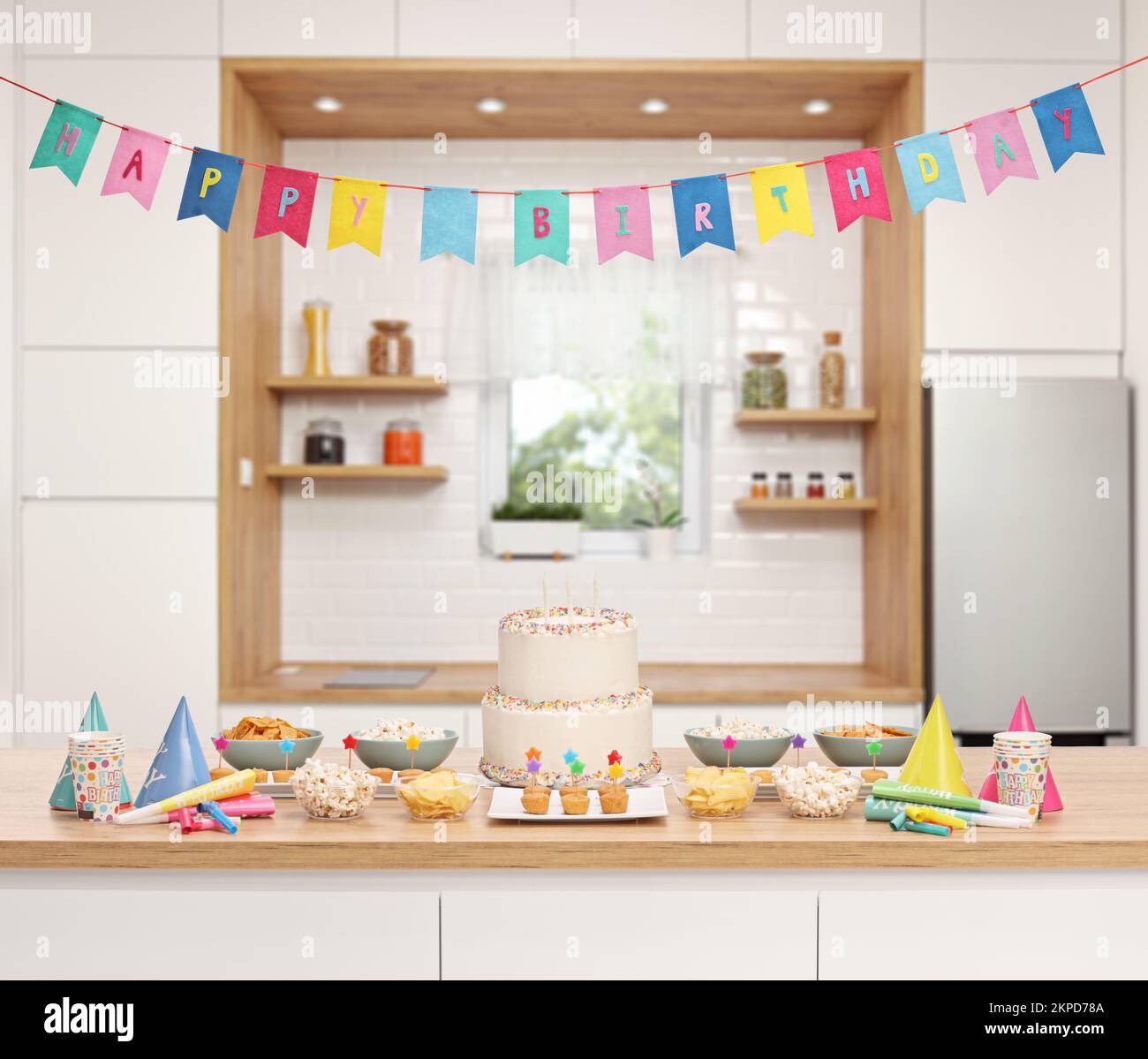 Kitchen decorated for a birthday party with cake and snacks on a wooden ...