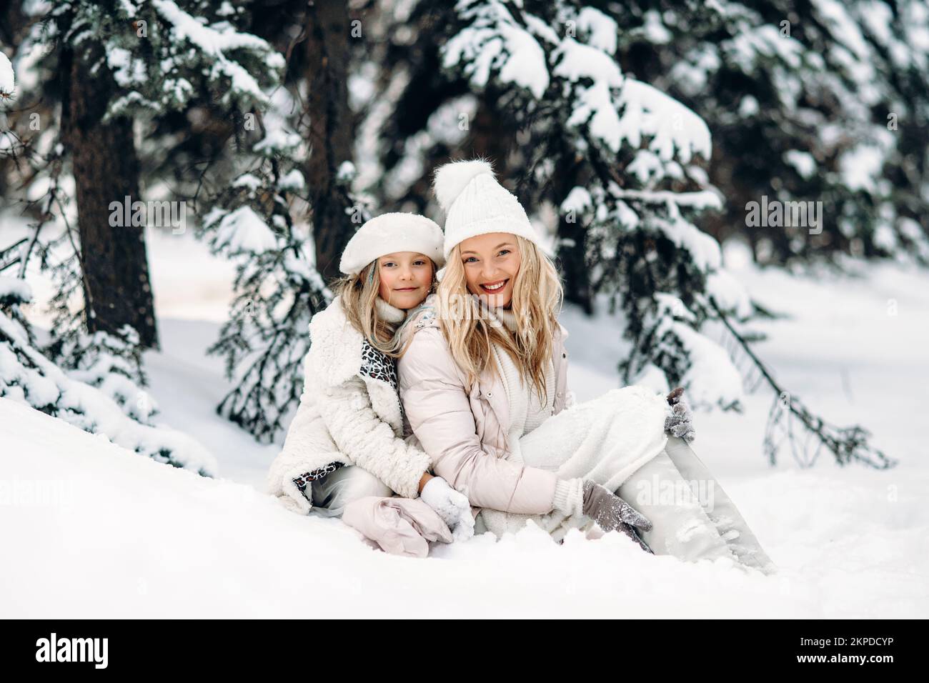 Handsome mother and daughter are having fun outdoor in winter time ...
