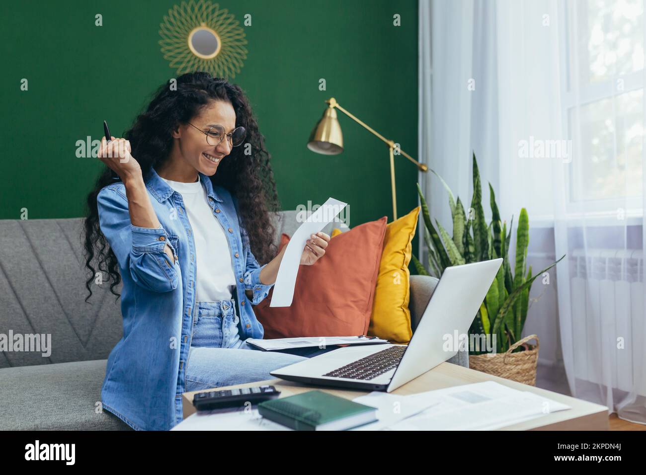 Young Latin American businesswoman using calculator and laptop working ...