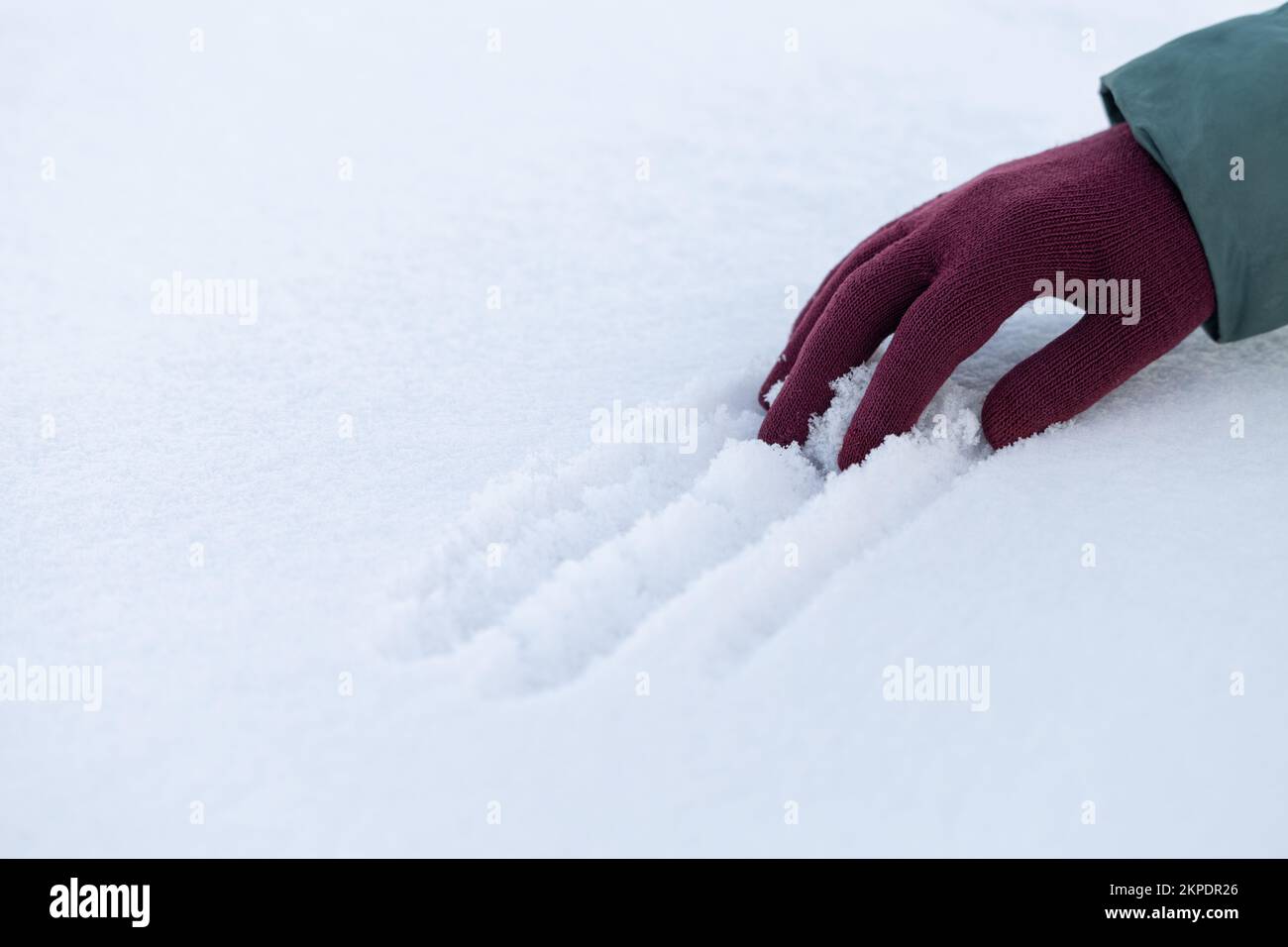 a man runs his hand over a snow-covered surface. hand touching snow ...