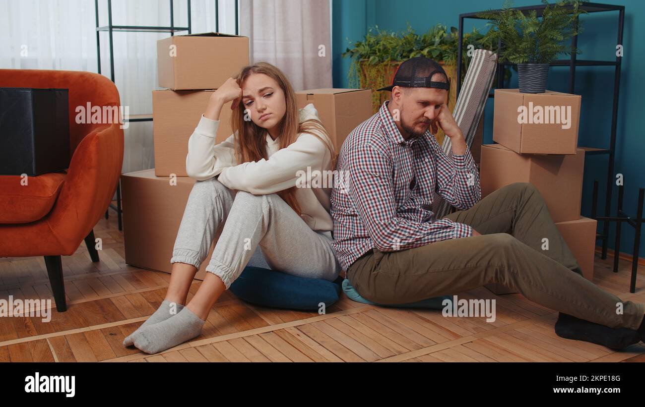 Sad tired married couple man woman leave house sit on floor near ...