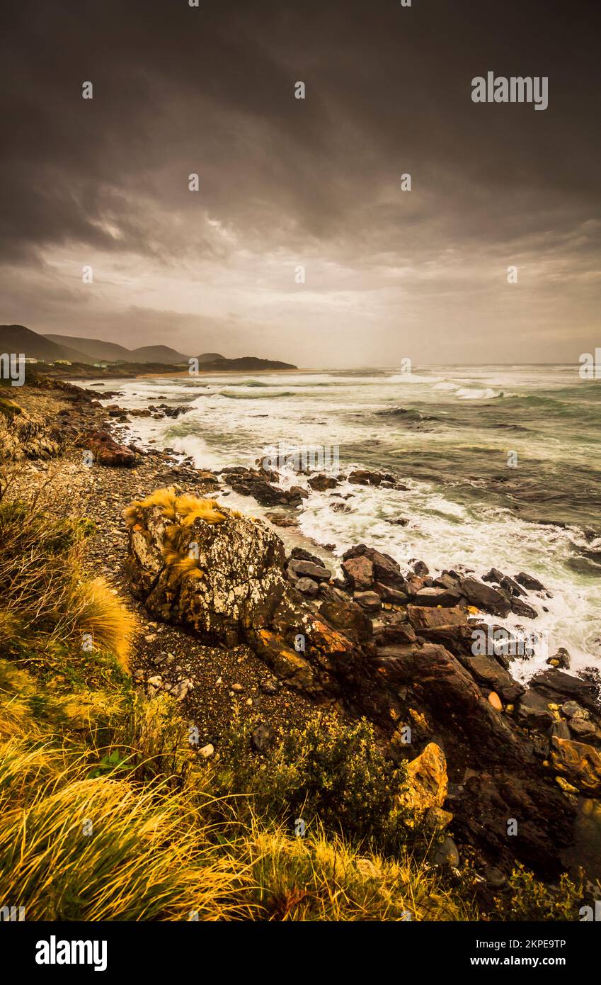 Wild overcast bay with windswept seas and distant rain. Trial Harbour ...