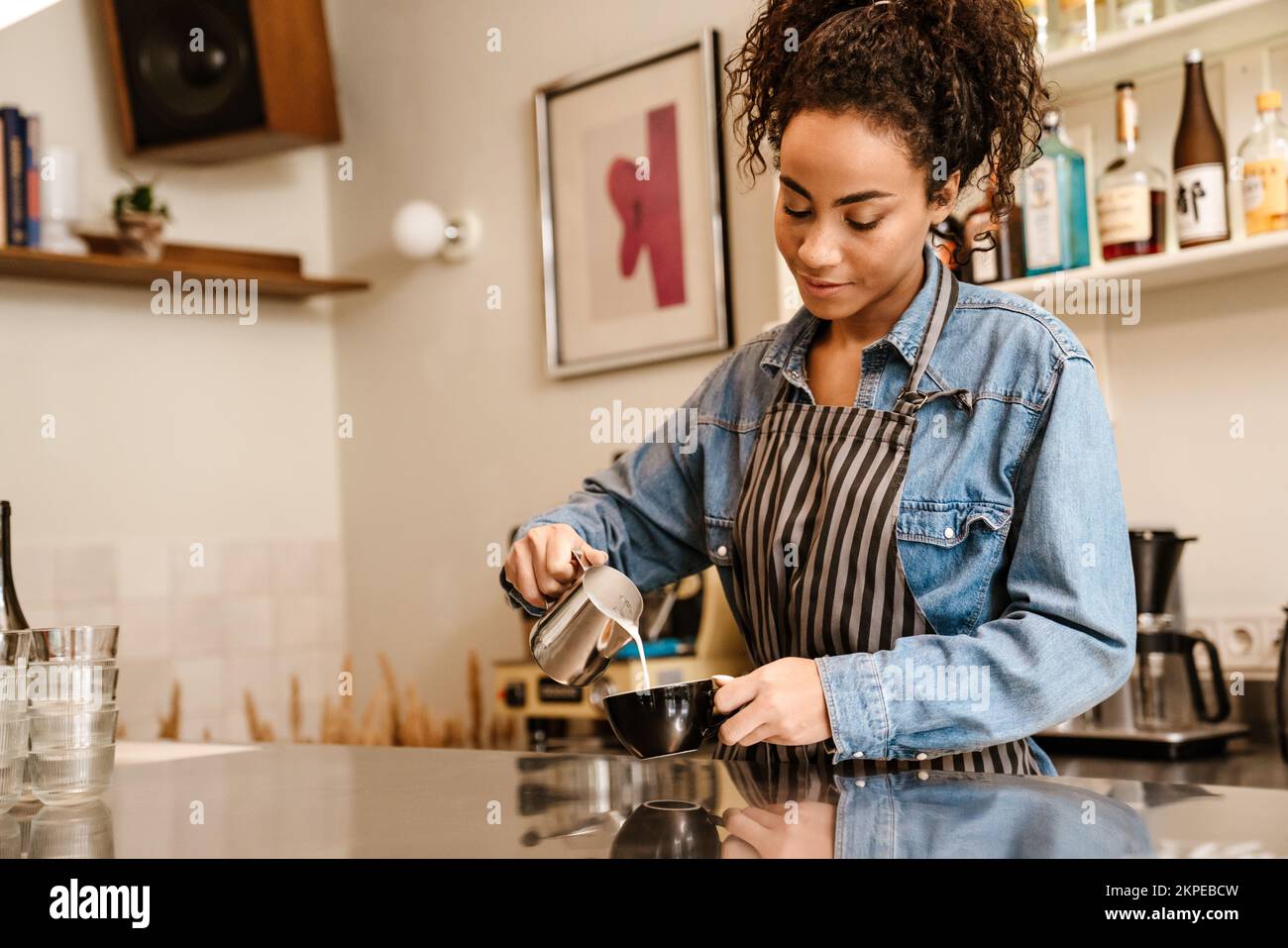 Young black barista wearing apron making coffee while working in cafe ...