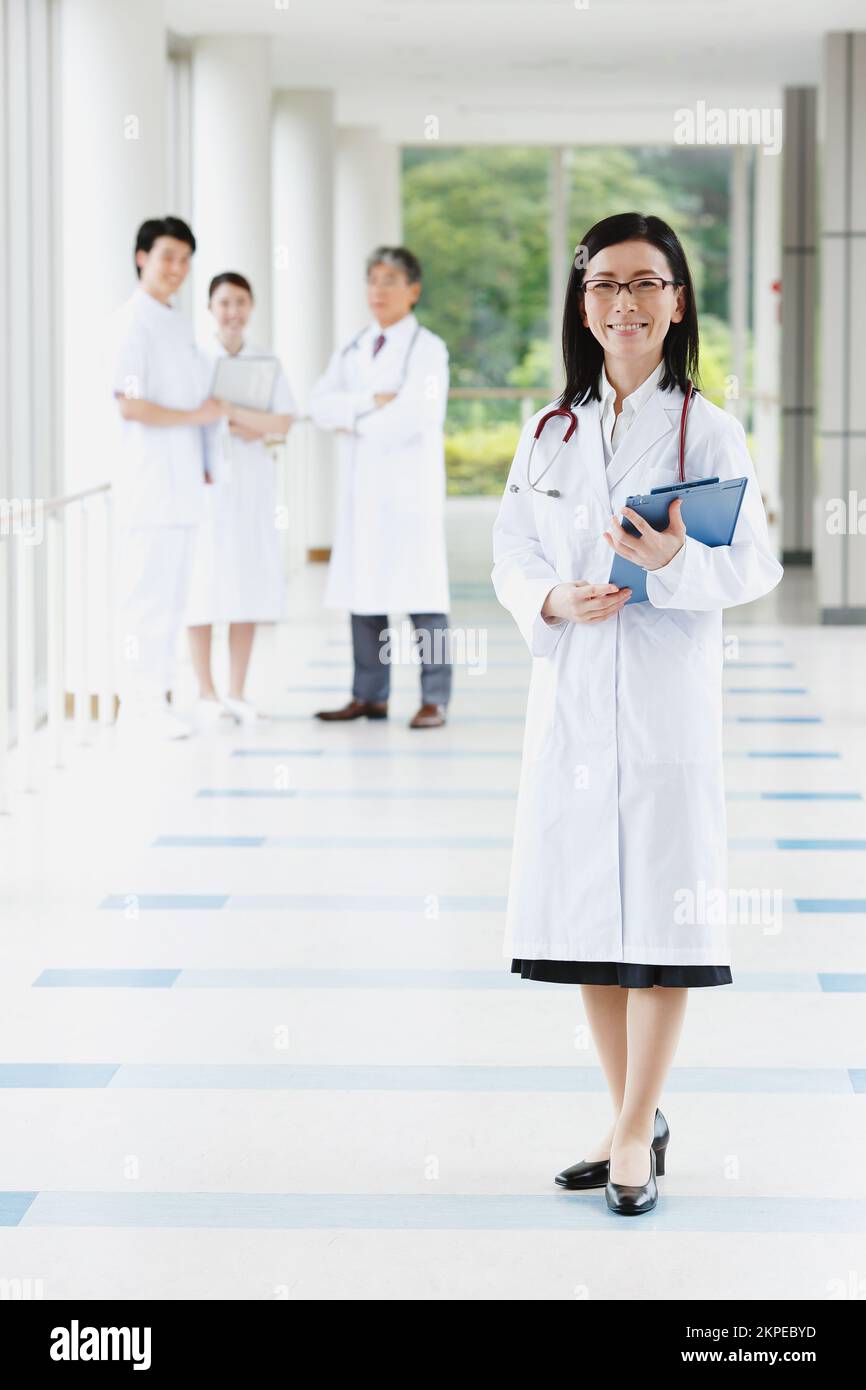 Smiling doctor and medical team in the hallway Stock Photo - Alamy