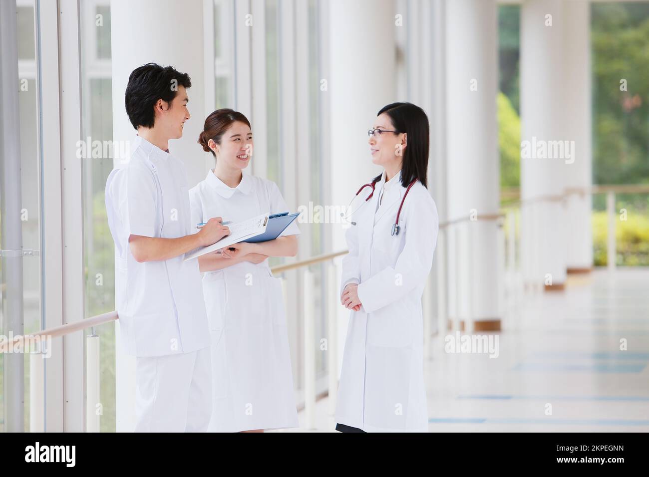 Two nurses and a doctor talking in the hallway Stock Photo - Alamy