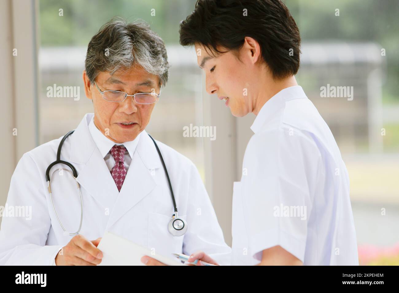 Japanese doctor and a young male nurse having a conversation in the ...
