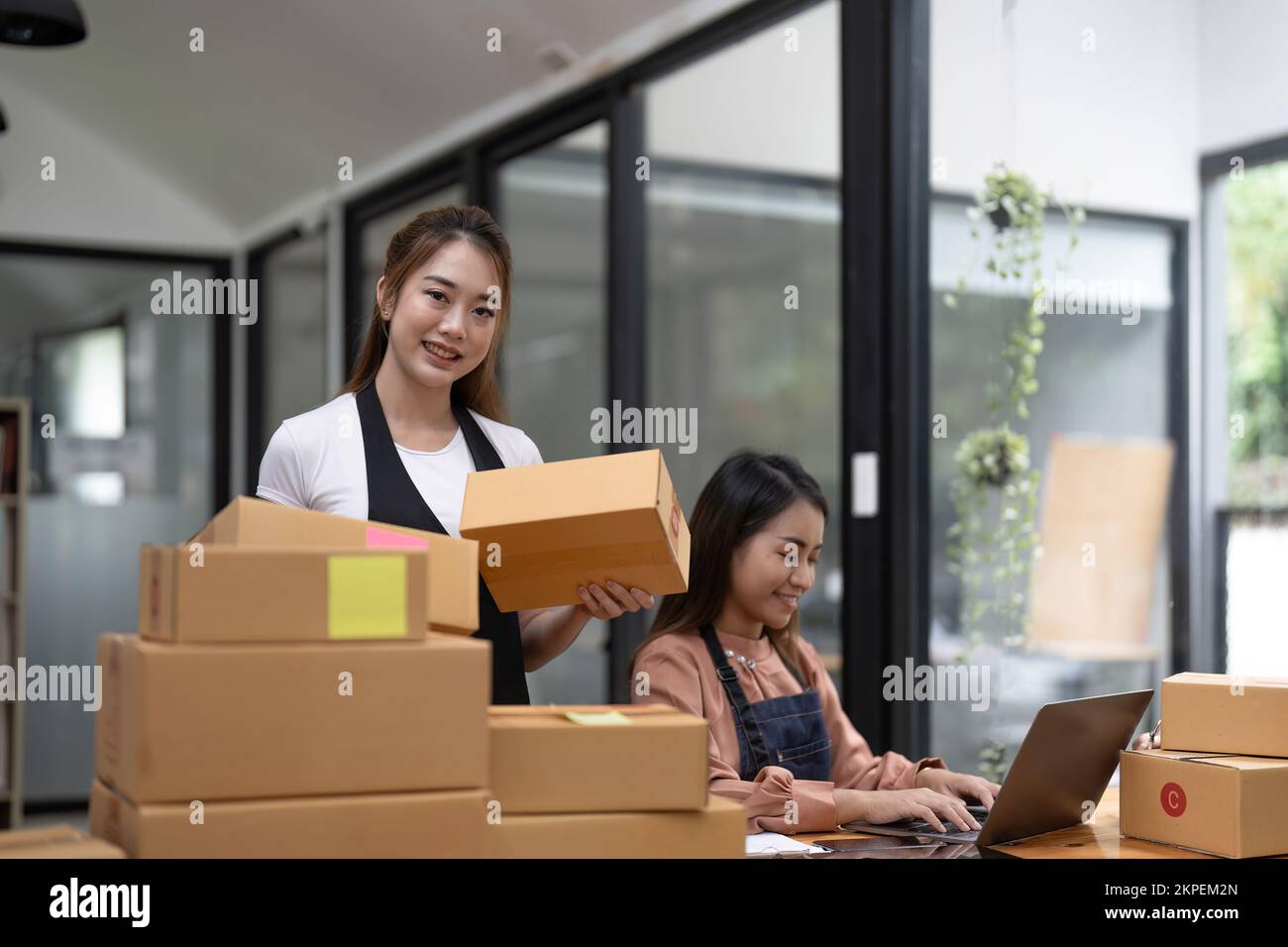 Two Asian woman working together for SME project. Young Owner people ...