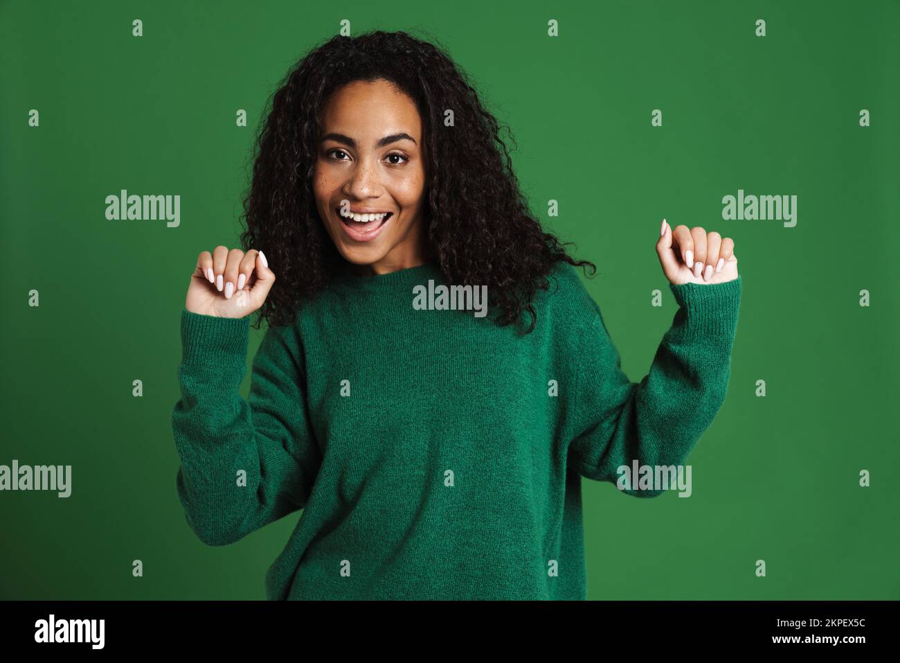 Young black woman wearing sweater laughing and dancing isolated over ...