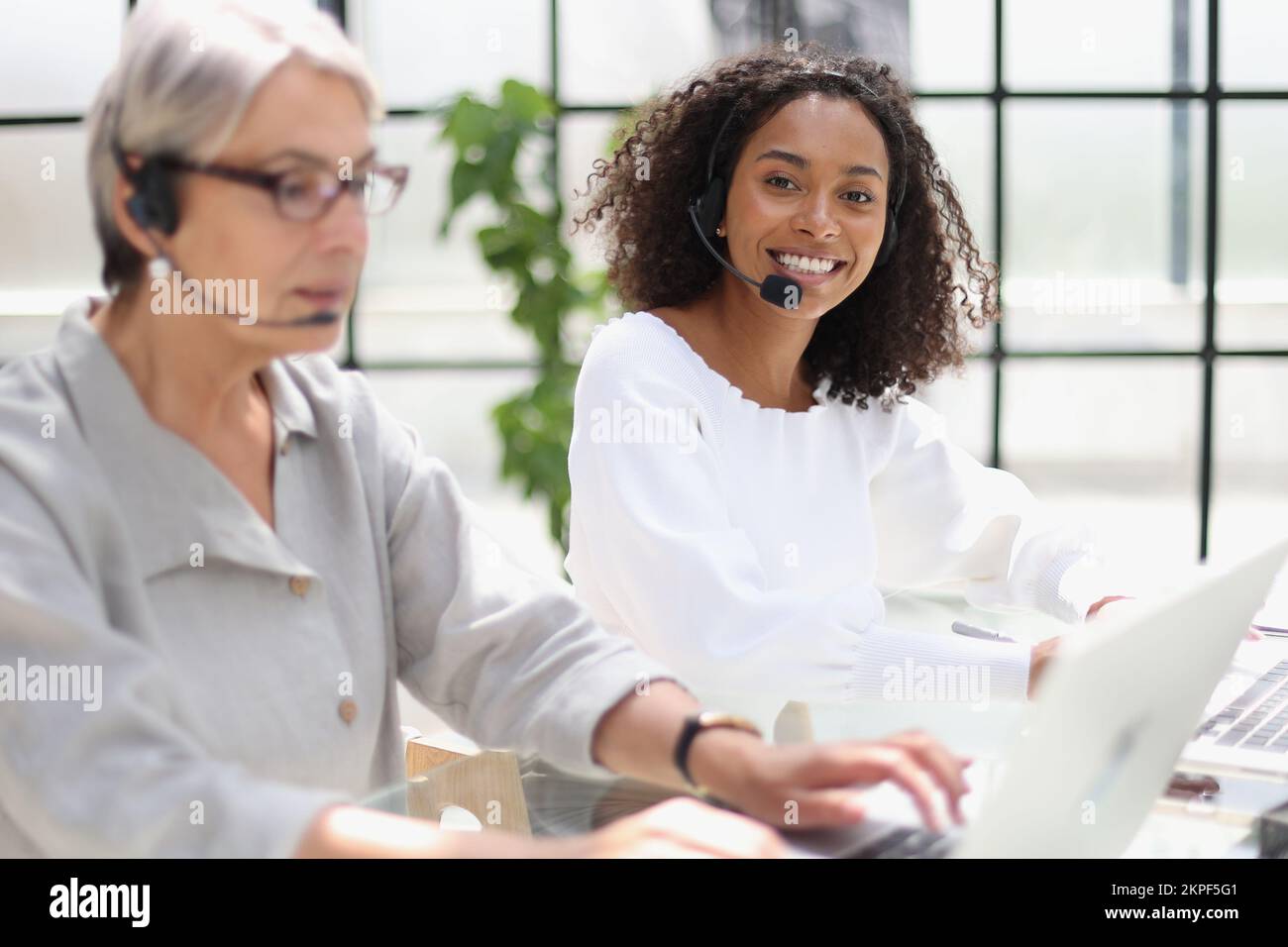 Young friendly operator woman agent with headsets working in a call centre Stock Photo - Alamy