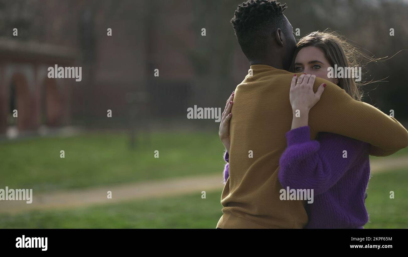 Interracial couple empathic embrace. Young woman romantic connection ...