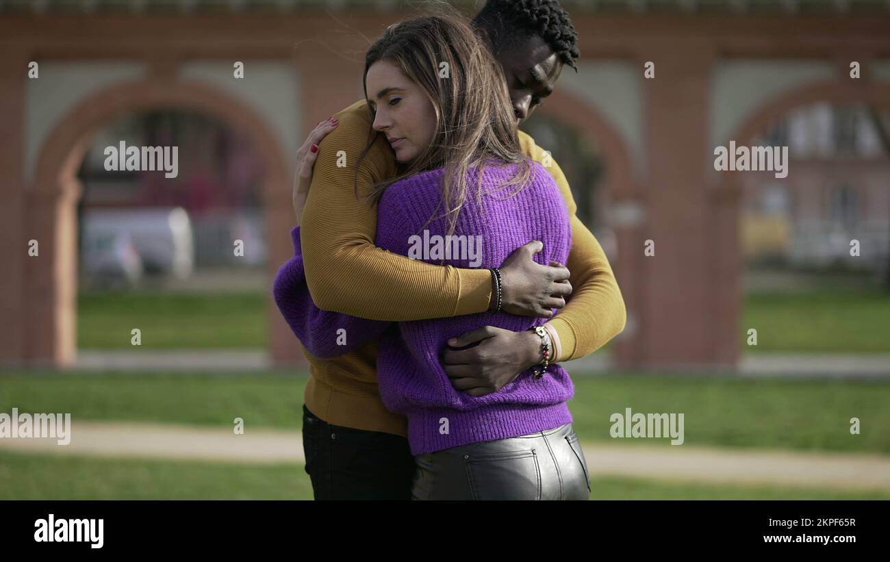 Interracial couple empathic embrace. Young woman romantic connection ...