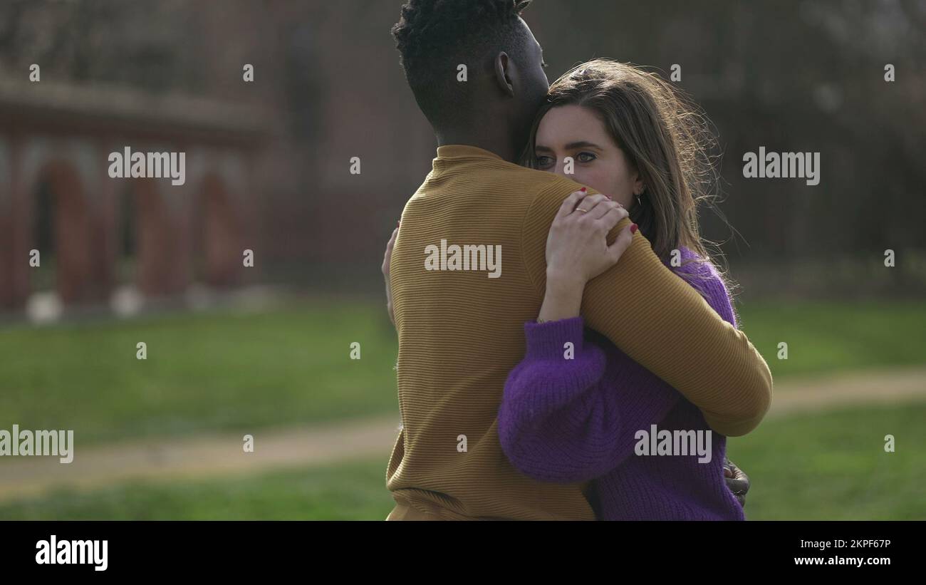 Interracial couple empathic embrace. Young woman romantic connection ...