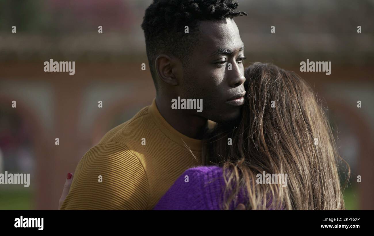 Interracial couple empathic embrace. Young woman romantic connection ...
