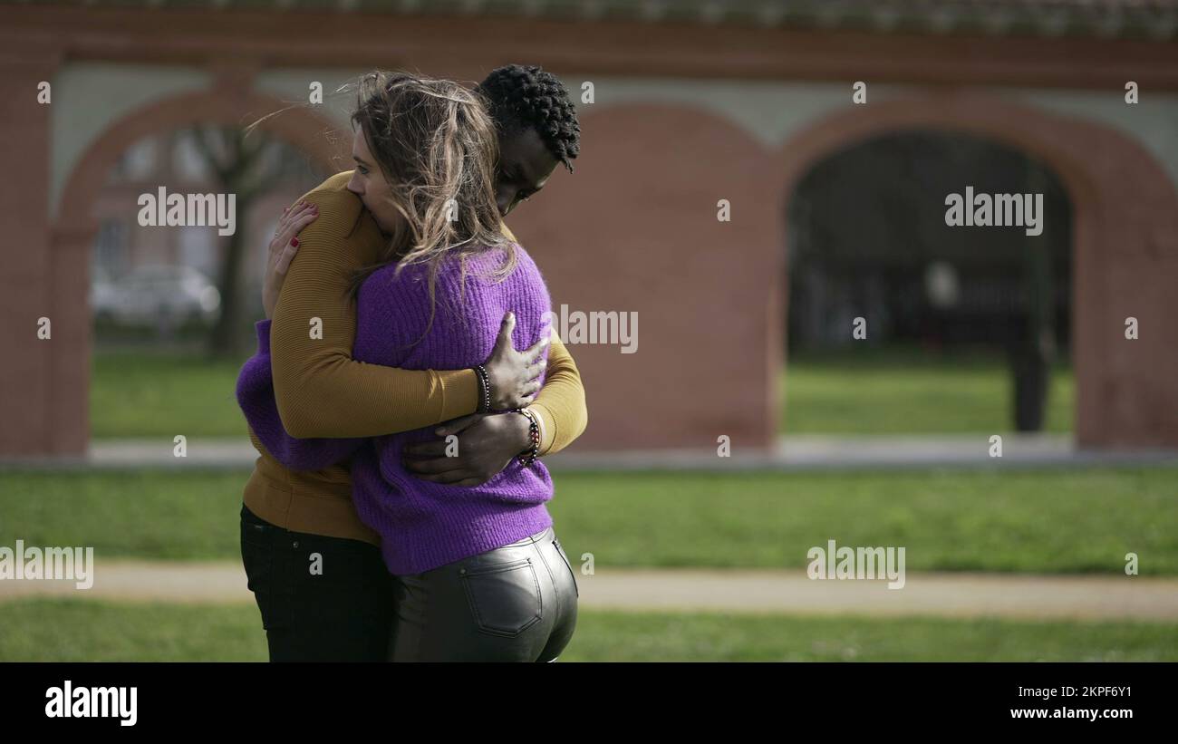 Interracial couple empathic embrace. Young woman romantic connection ...