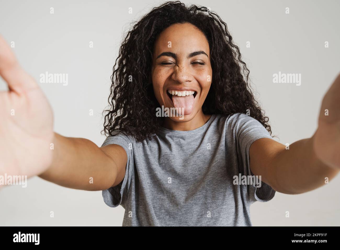 Young Black Woman Showing Her Tongue While Taking Selfie Photo Isolated
