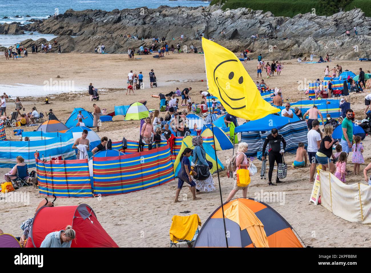 A flag with a smiley face symbol fluttering on a busy crowded Fistral ...
