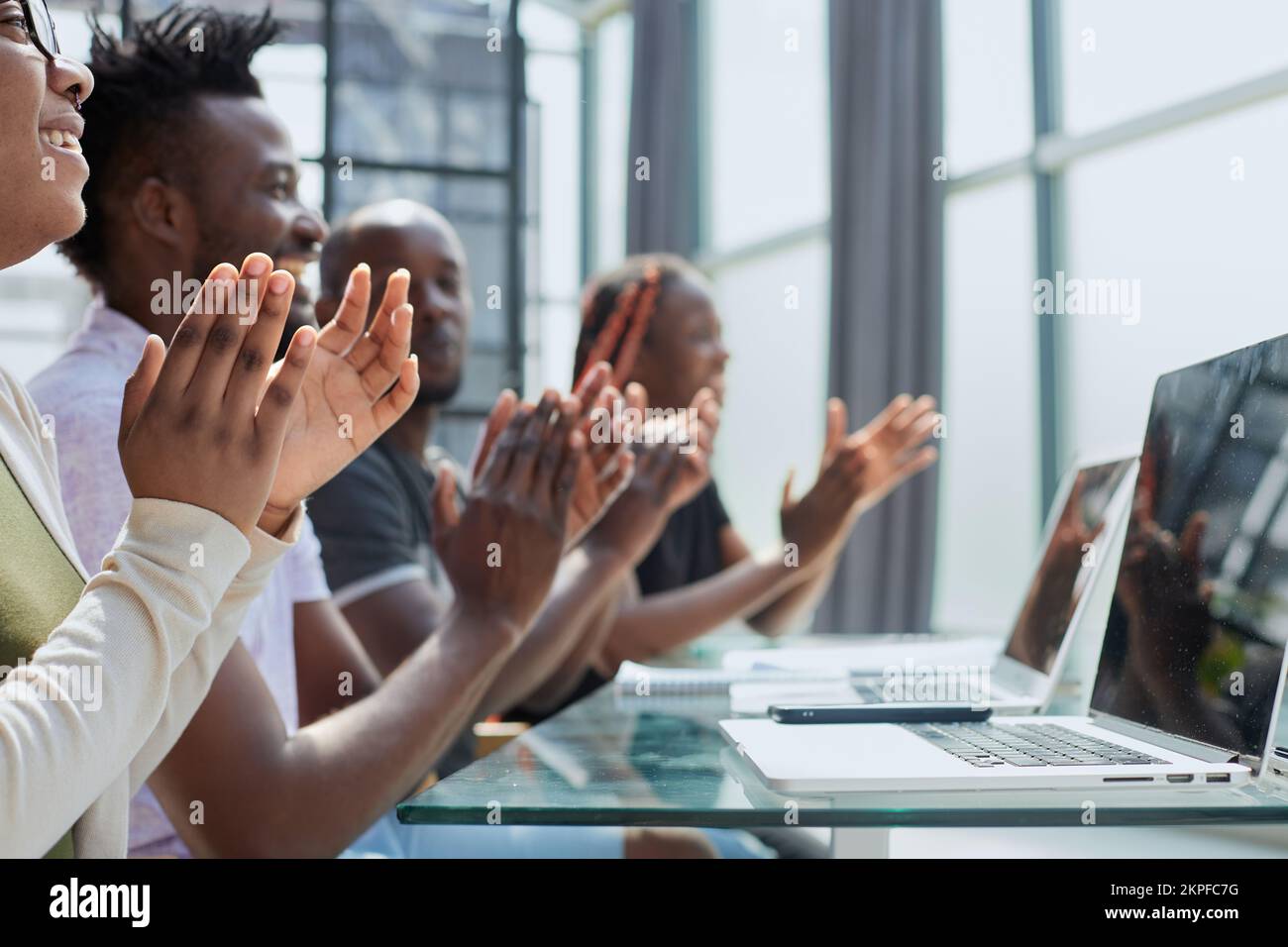 Multi ethnic business group greets somebody with clapping and smiling ...