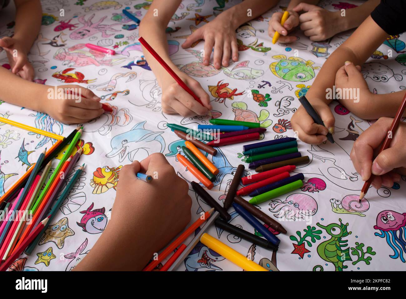 Kids hands holding wax crayons and drawing. Closeup Stock Photo - Alamy